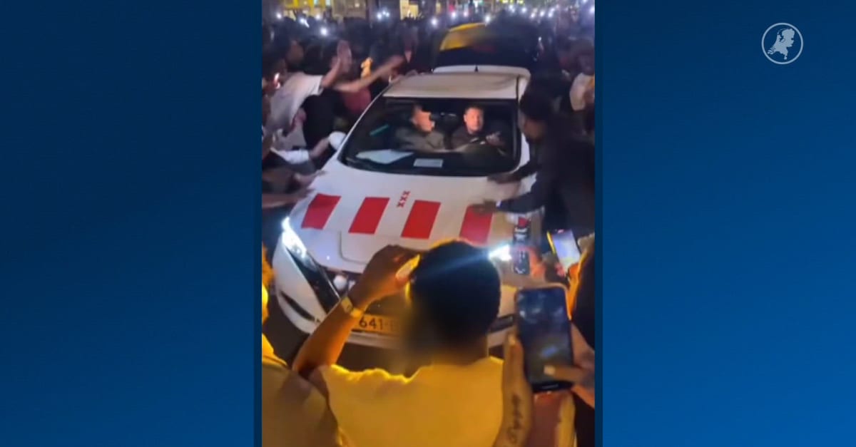 Menigte klimt op auto van handhaving Amsterdam