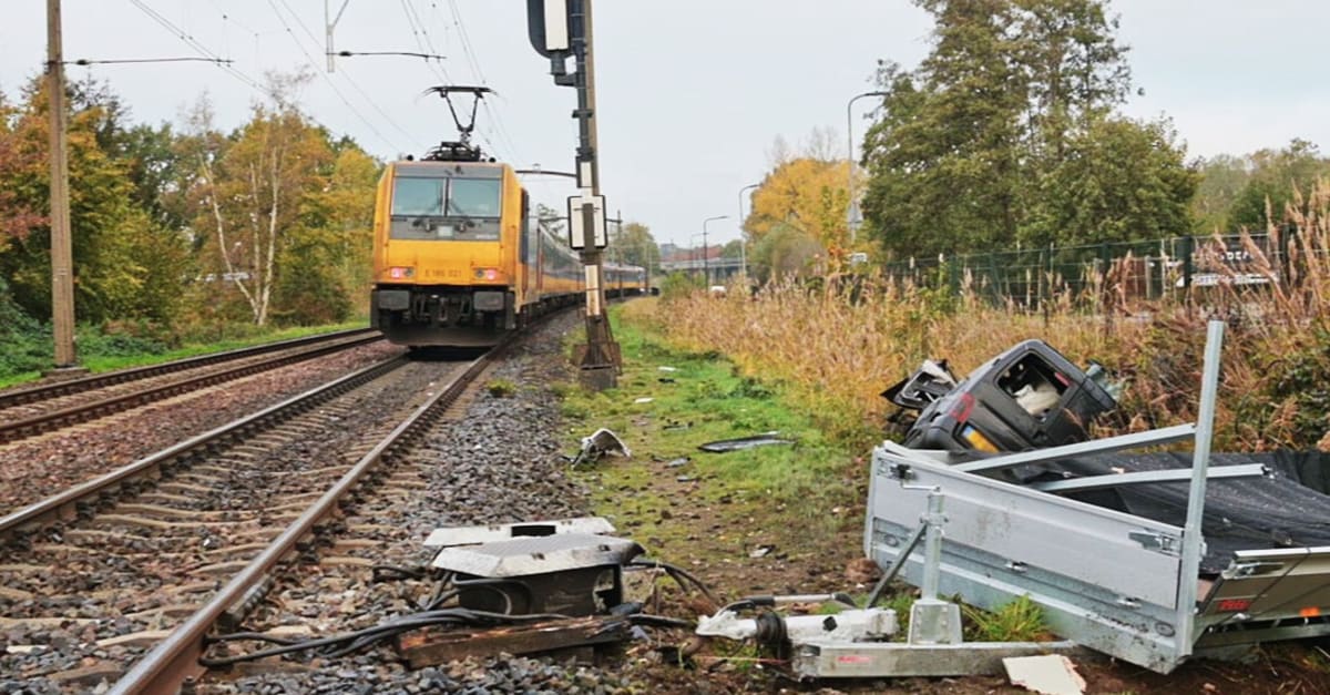 Trein boort zich door vaststaande auto met aanhanger op overweg | Hart ...