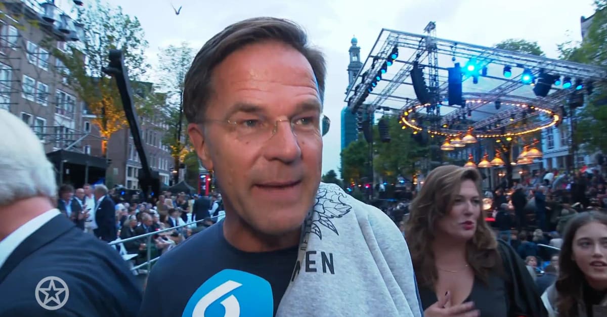 Shownieuws: Mark Rutte en publiek 'tot tanden bewapend tegen de regen ...